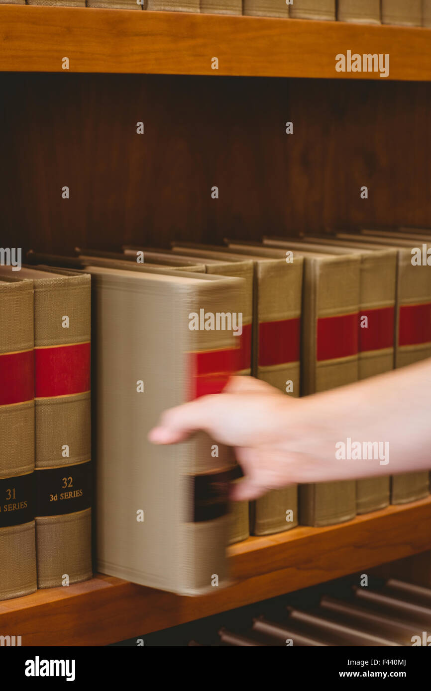 Hand taking a book from bookshelf Stock Photo - Alamy