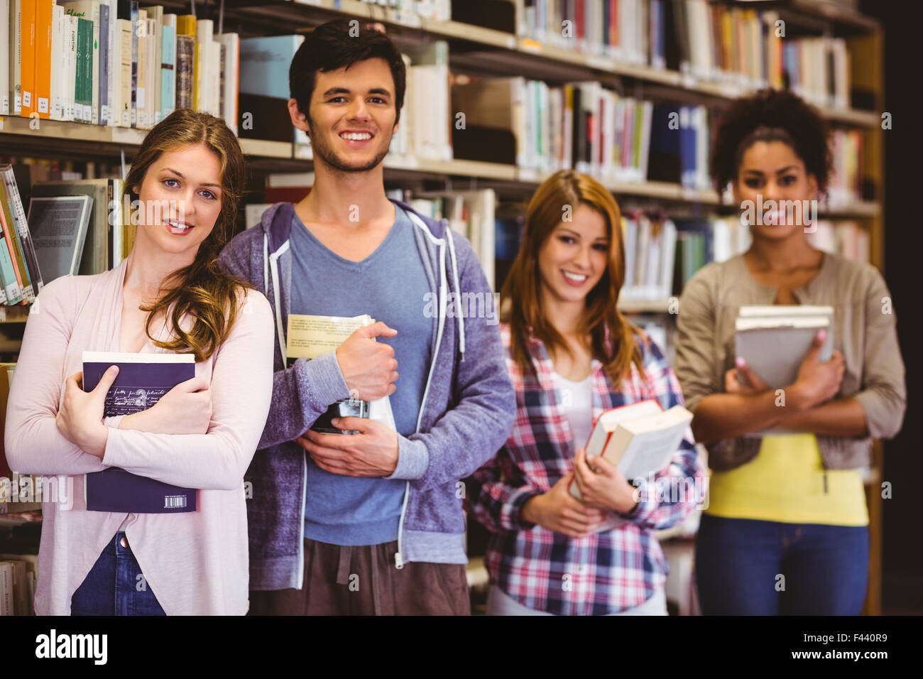 Happy students holding books in row Stock Photo - Alamy