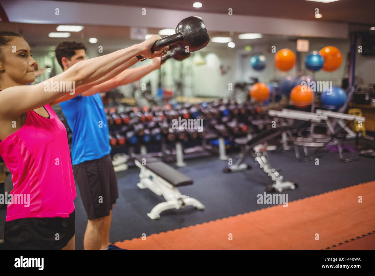 Fit couple working out in weights room Stock Photo - Alamy