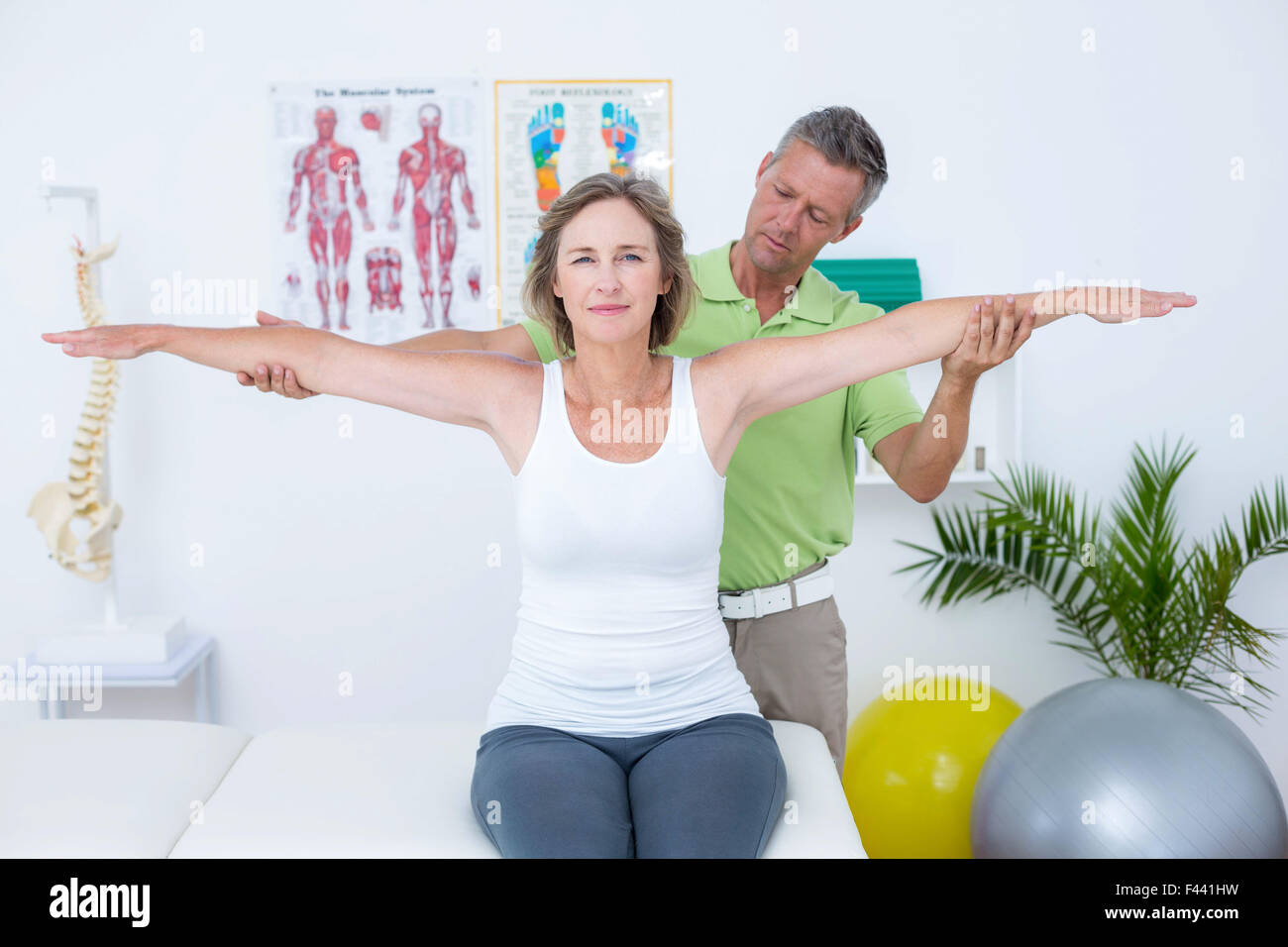 Doctor stretching his patients arms Stock Photo - Alamy