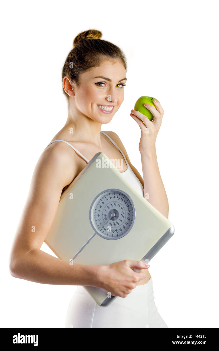 Slim woman holding scales and apple Stock Photo - Alamy
