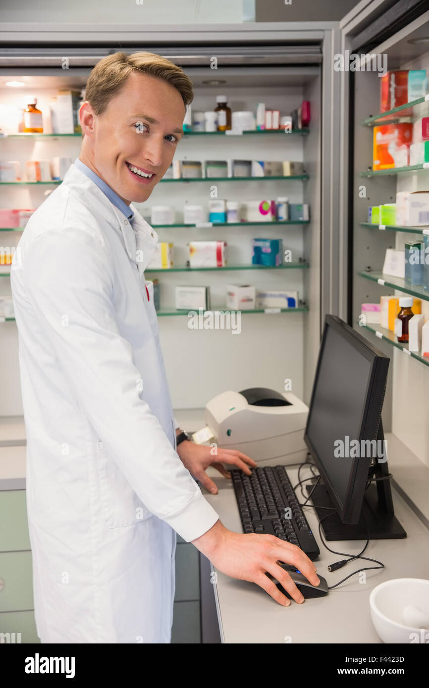 Handsome pharmacist using the computer Stock Photo - Alamy