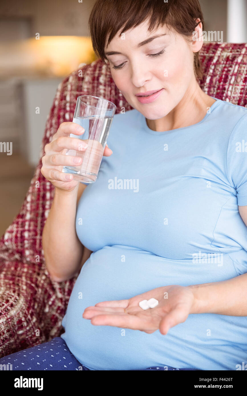 Pregnant woman taking a vitamin tablet Stock Photo - Alamy