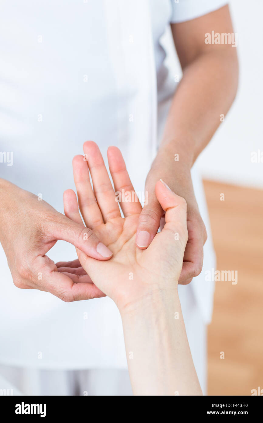 Physiotherapist examining her patients hand Stock Photo - Alamy