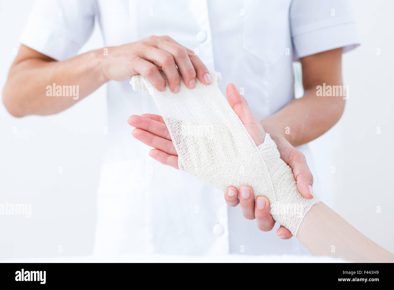 Doctor bandaging her patient wrist Stock Photo - Alamy