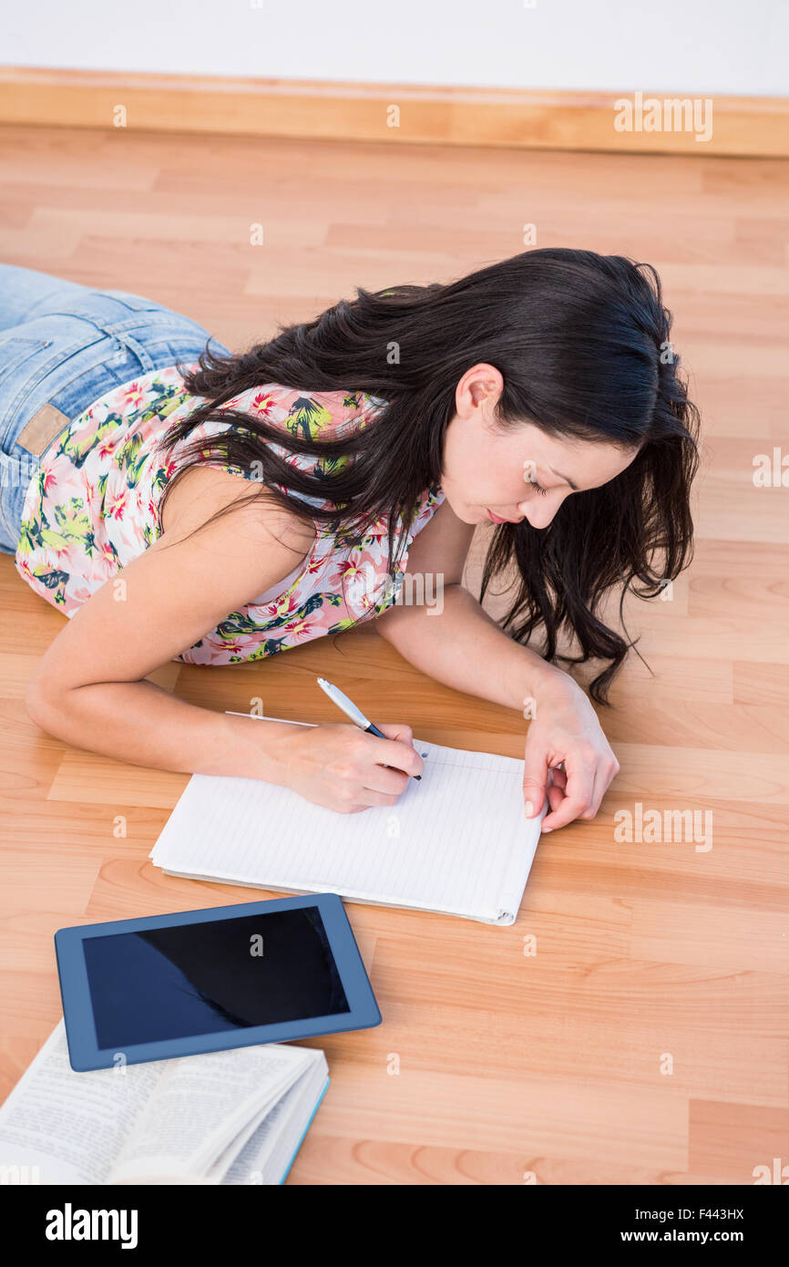Pretty brunette writing on a paper Stock Photo - Alamy