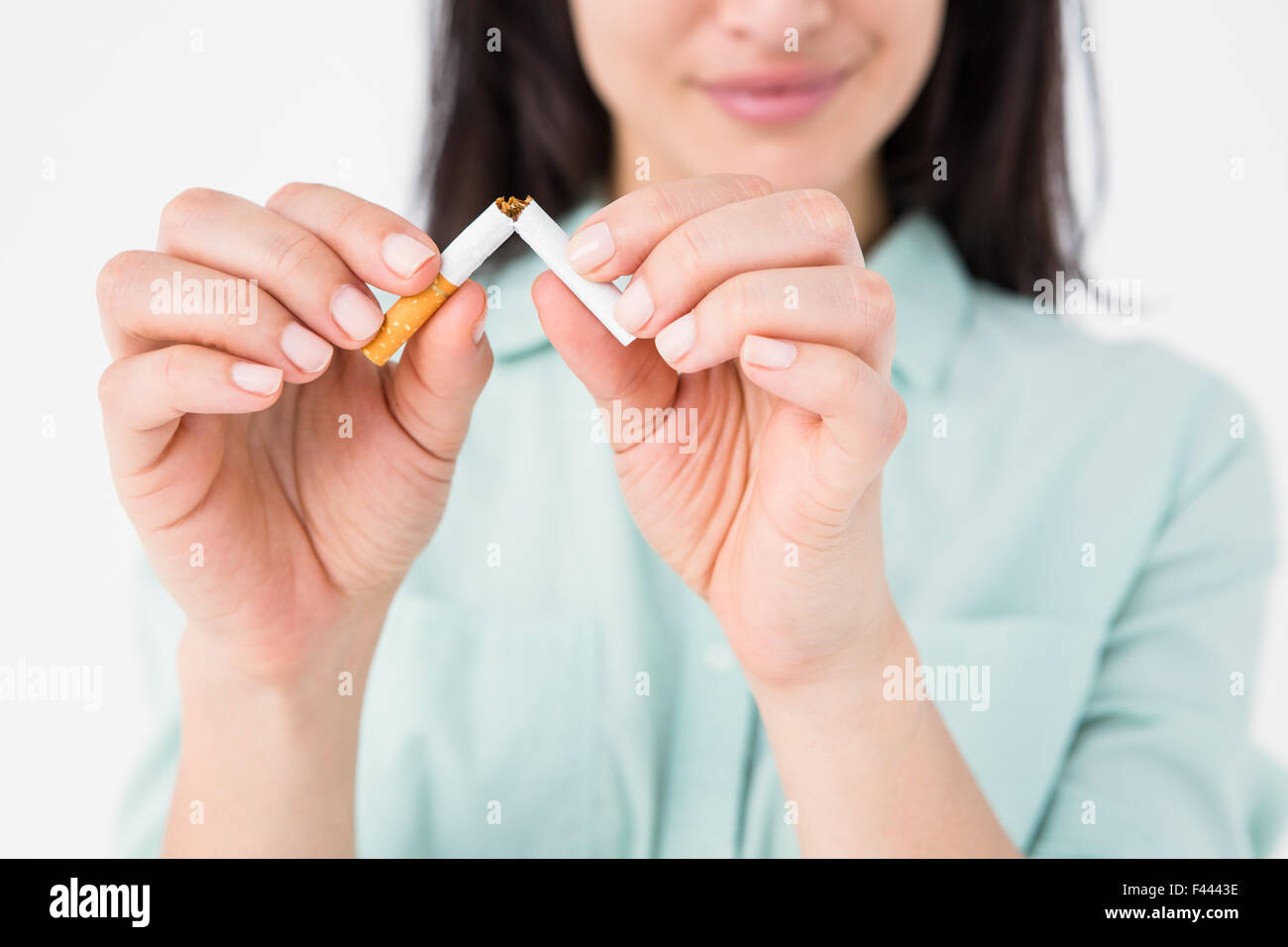 Smiling woman snapping cigarette in half Stock Photo - Alamy