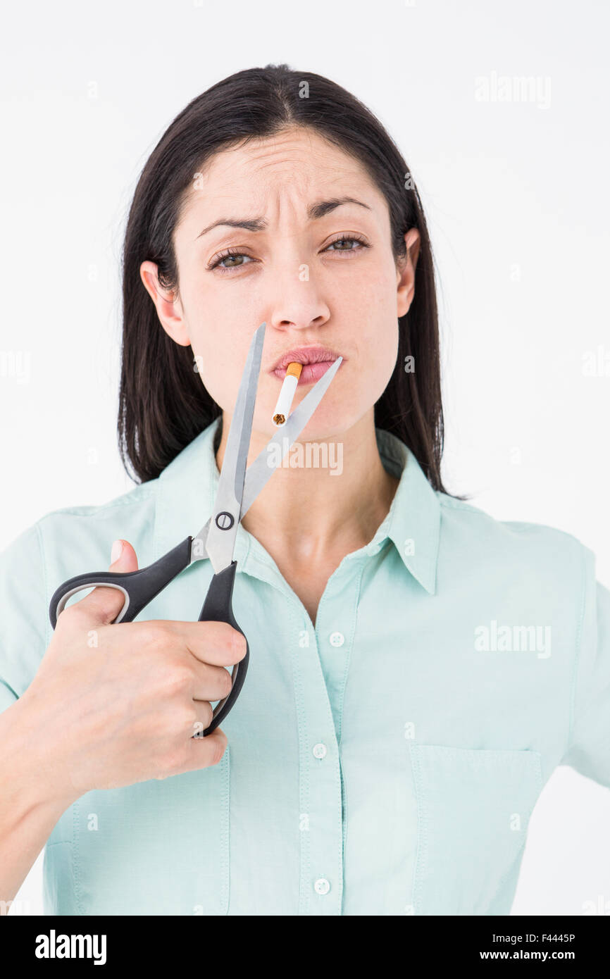 Brunette cutting cigarette with scissors Stock Photo - Alamy