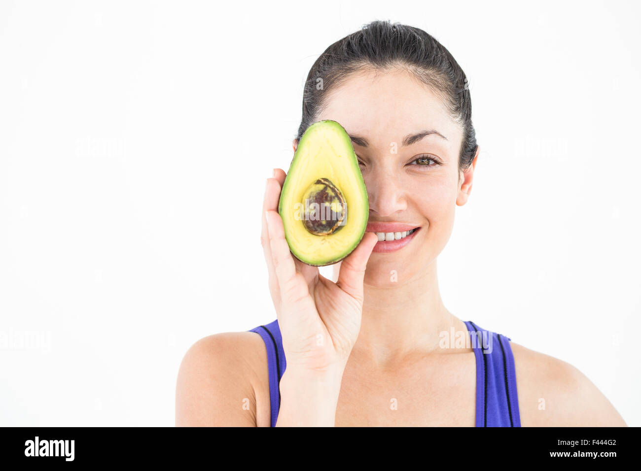 Pretty woman showing half of an avocado Stock Photo - Alamy