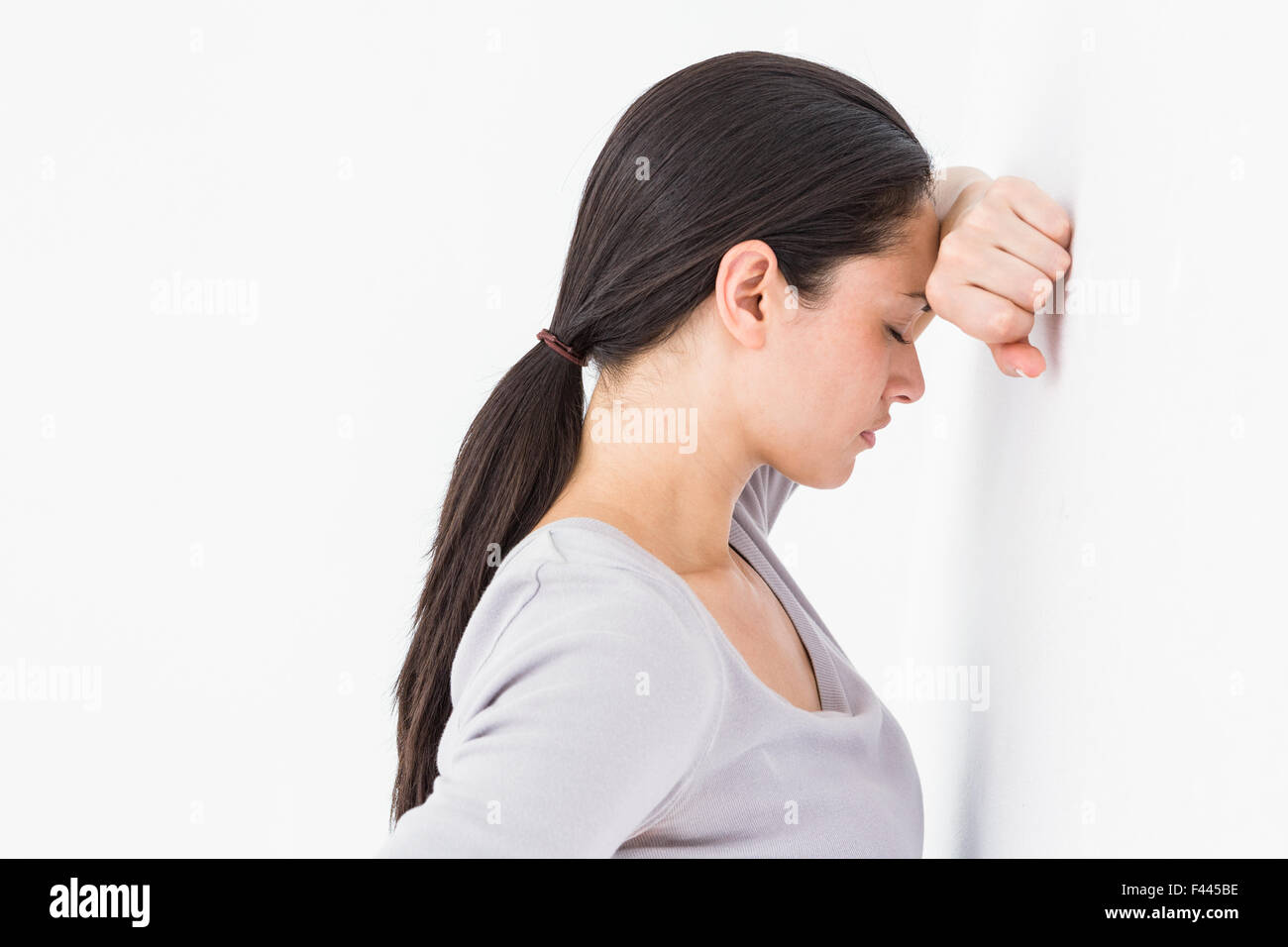 Sad woman leaning against the wall Stock Photo - Alamy