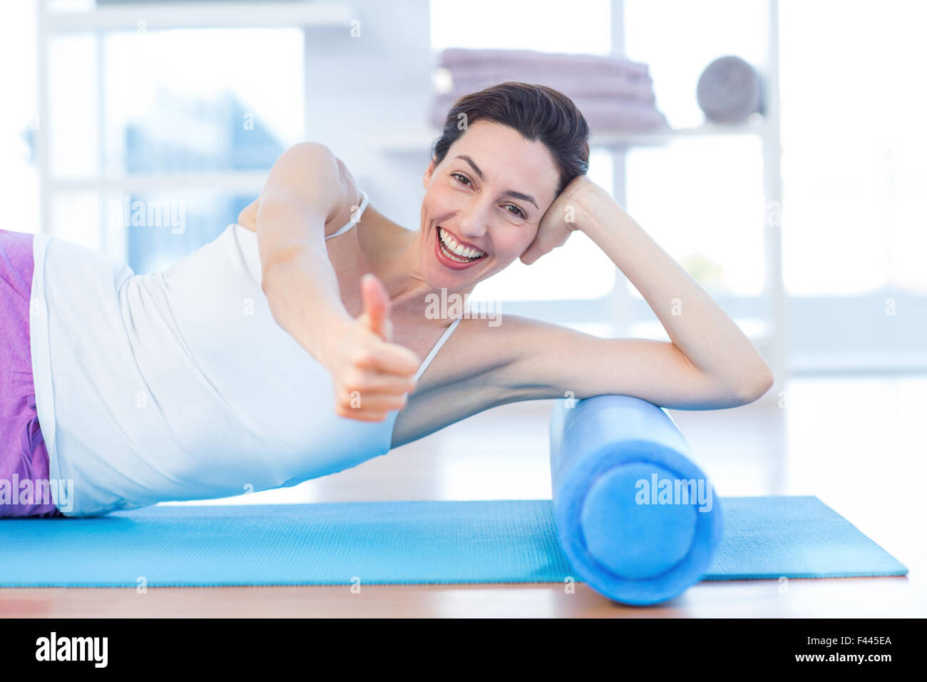 Smiling woman lying on exercise mat Stock Photo - Alamy