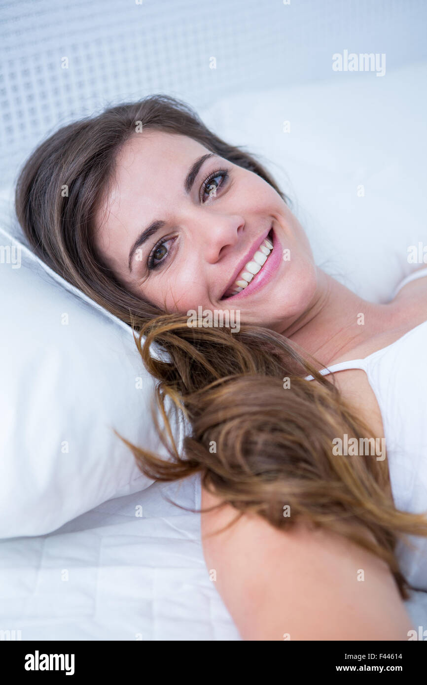 Happy woman in bed smiling at camera Stock Photo - Alamy