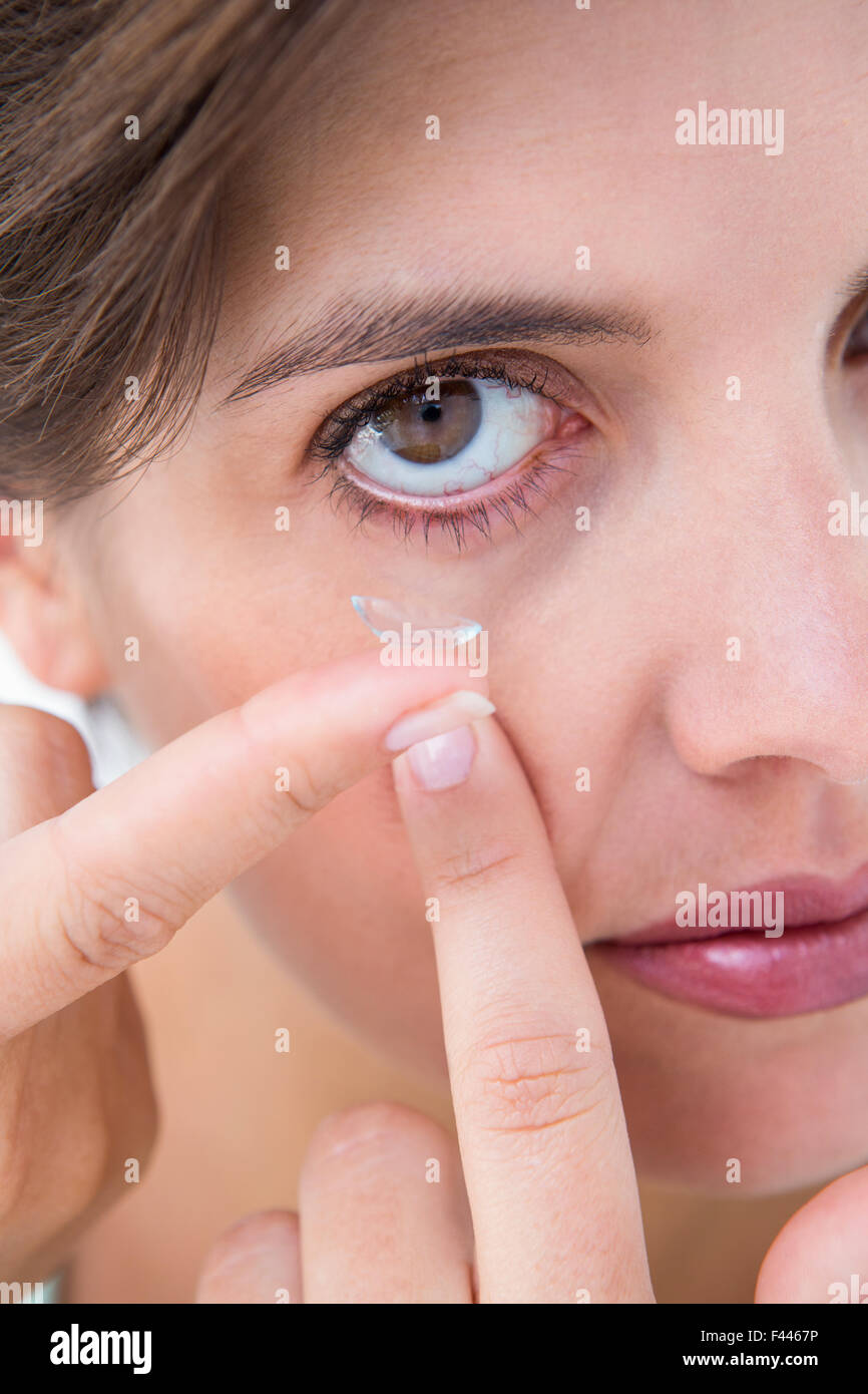 Pretty woman applying contact lens Stock Photo - Alamy