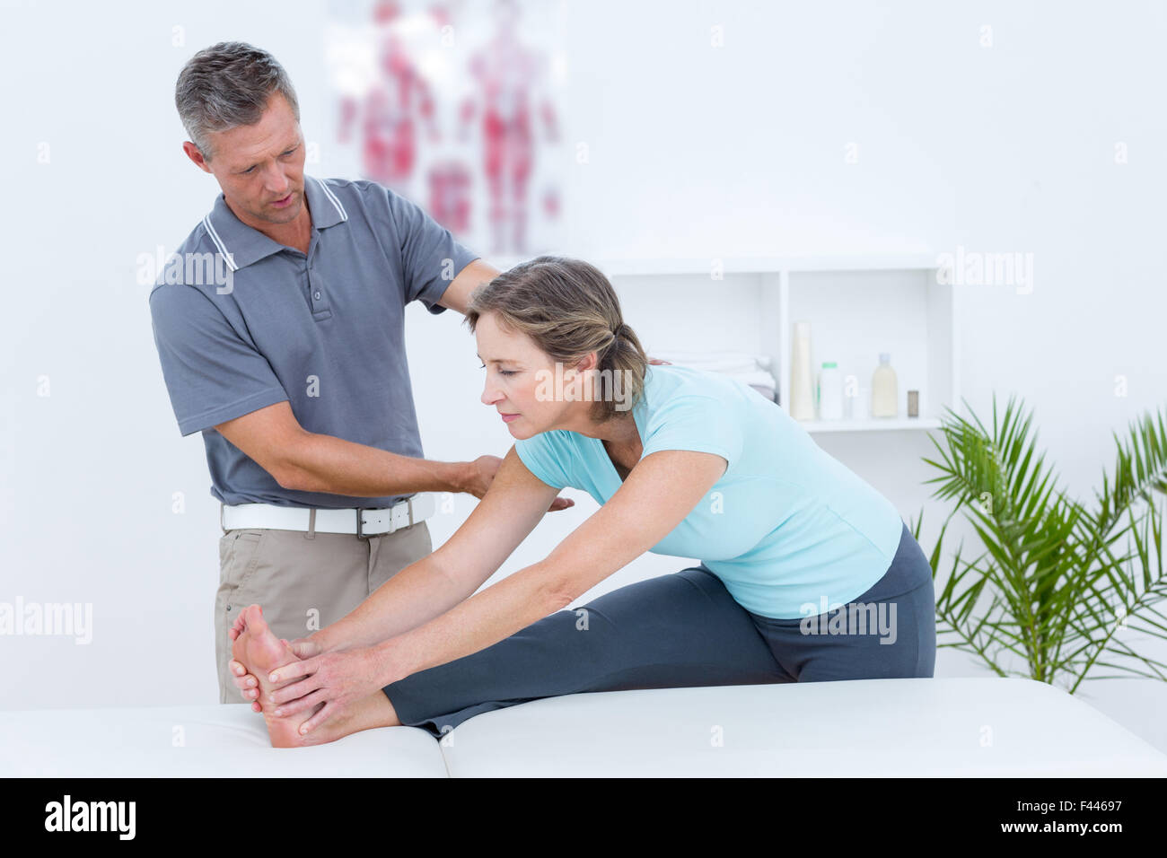 Physiotherapist helping his patient stretching Stock Photo - Alamy