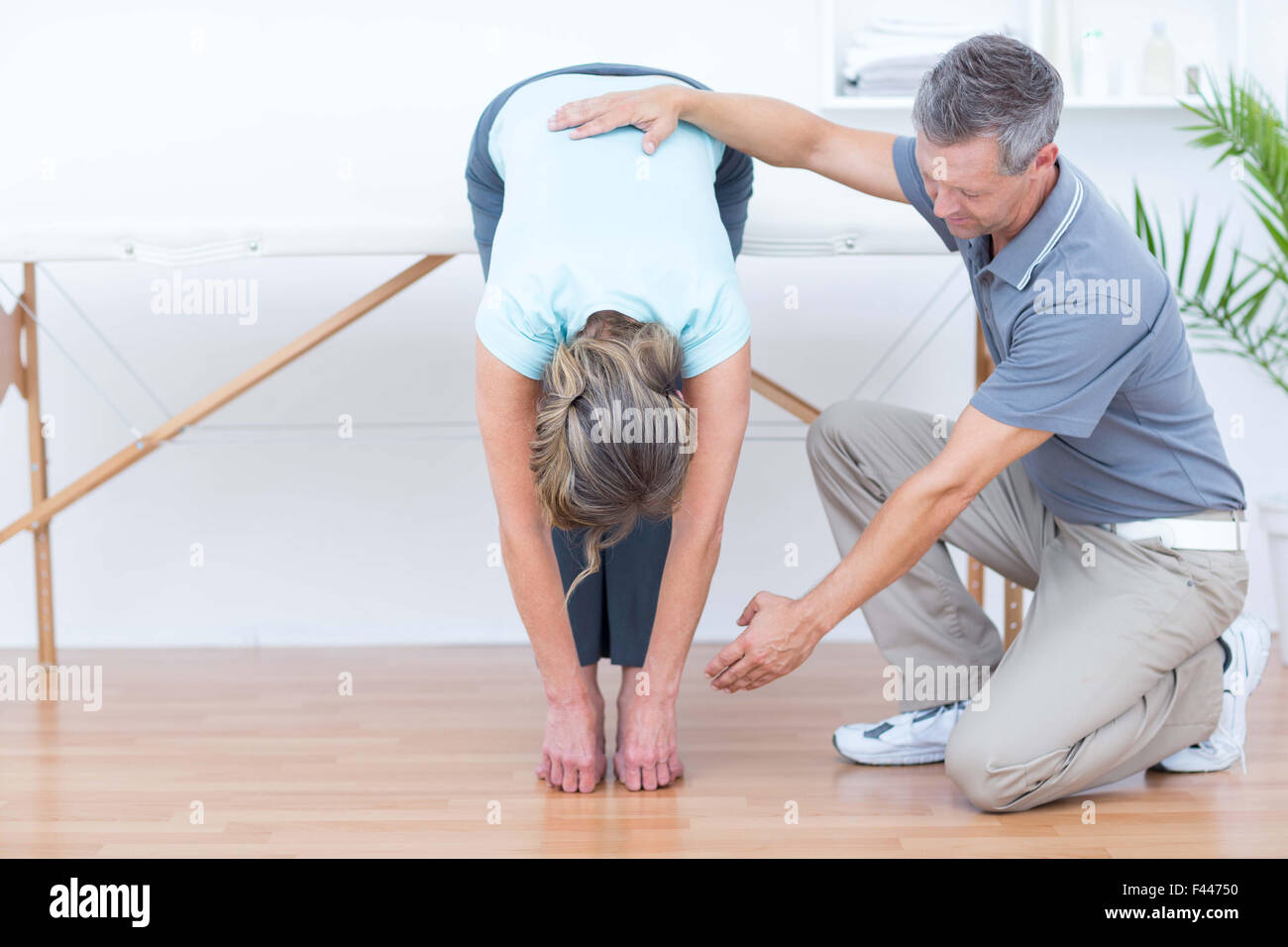 Physiotherapist helping his patient stretching Stock Photo - Alamy