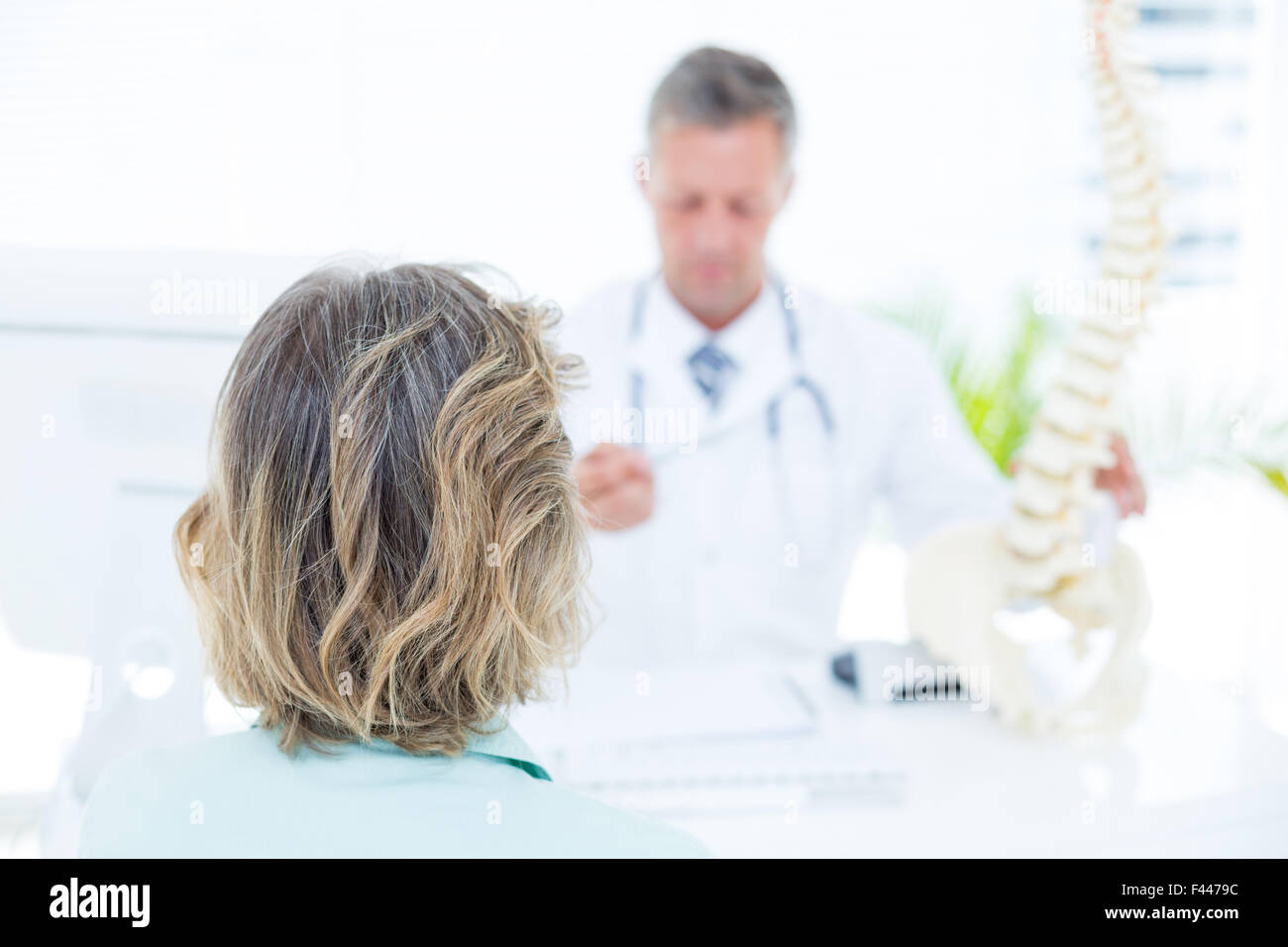 Doctor showing spine model to his patient Stock Photo - Alamy