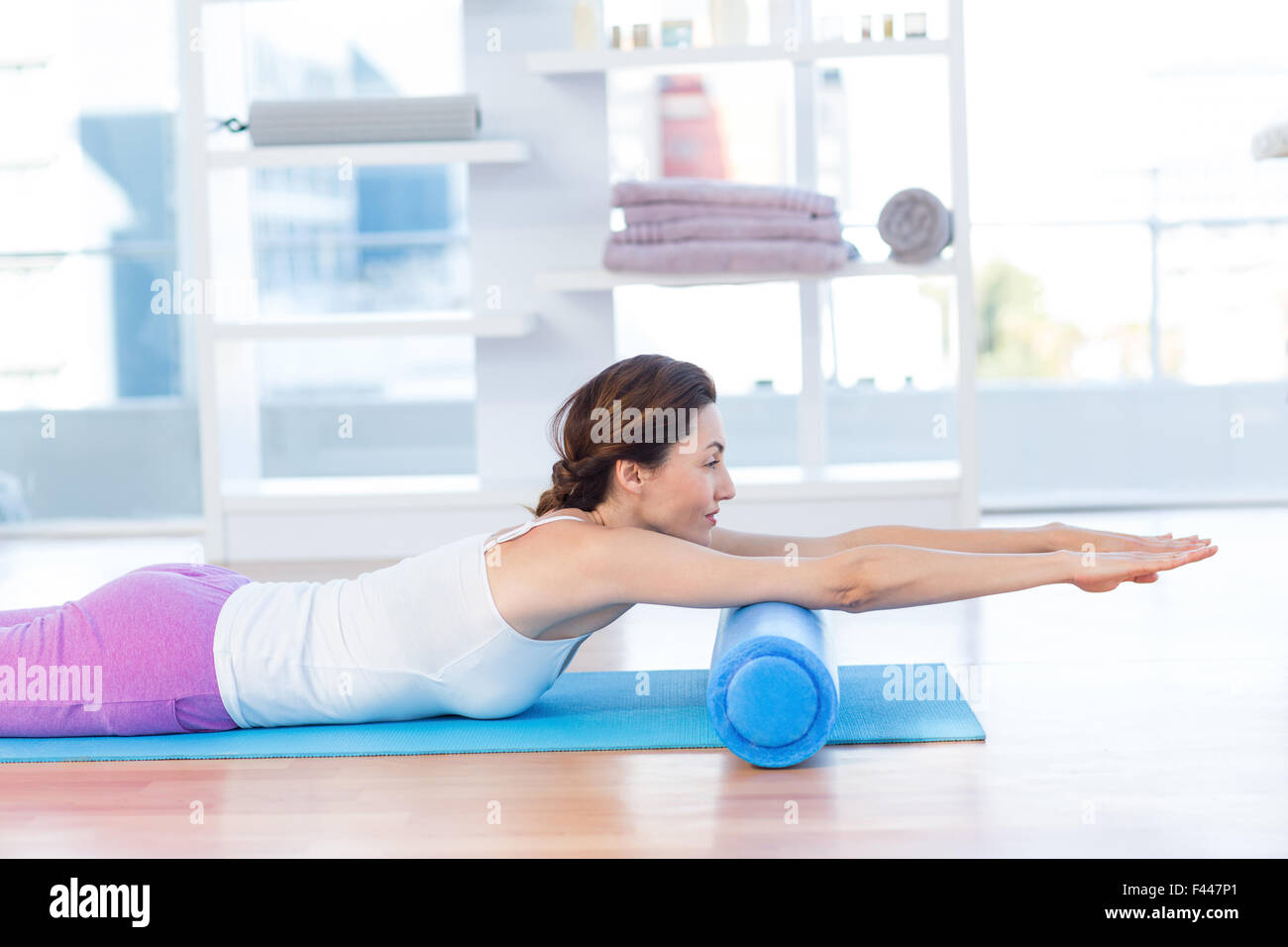 Smiling woman lying on exercise mat Stock Photo - Alamy