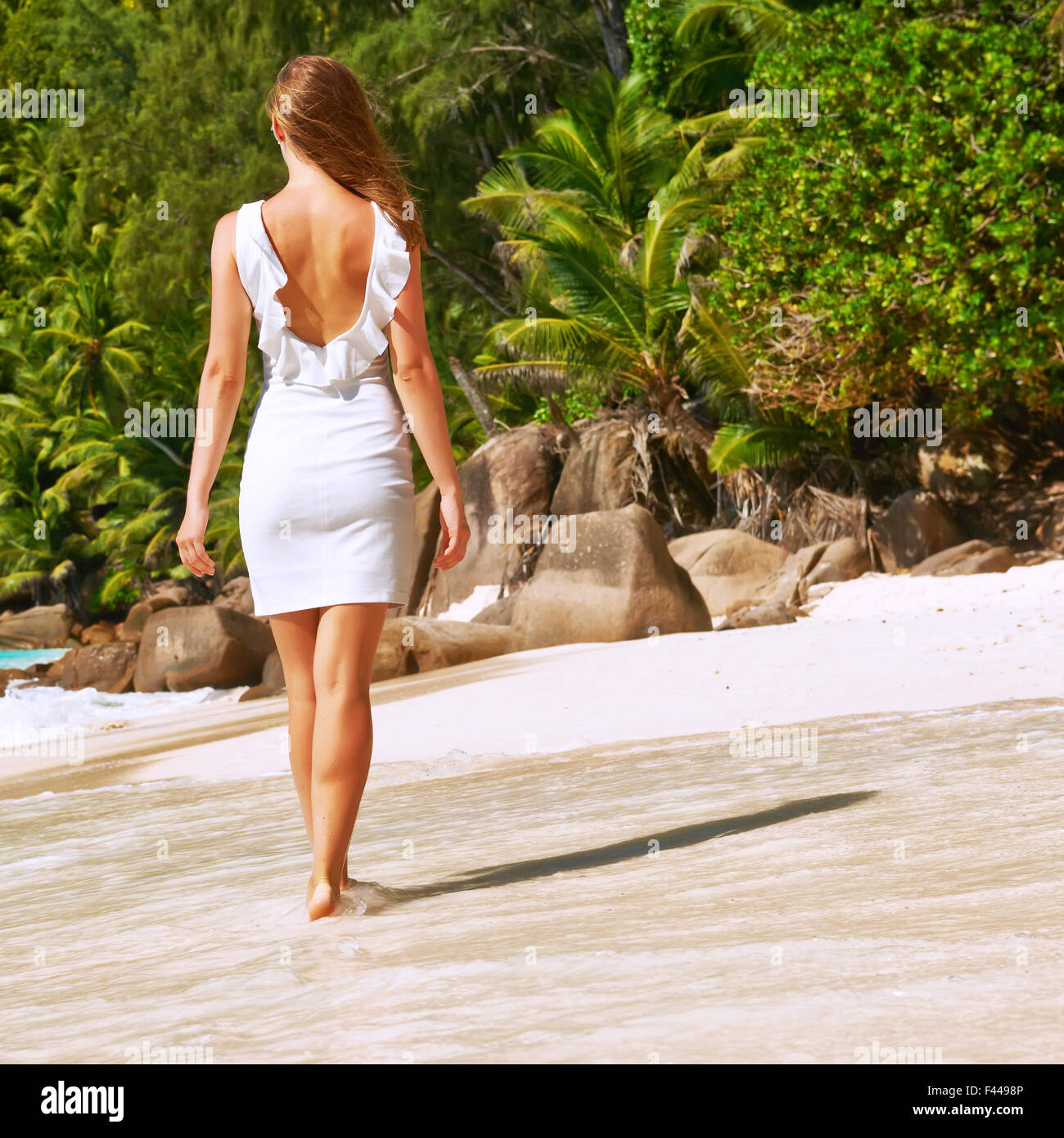 Woman wearing dress on beach at Seychelles Stock Photo - Alamy