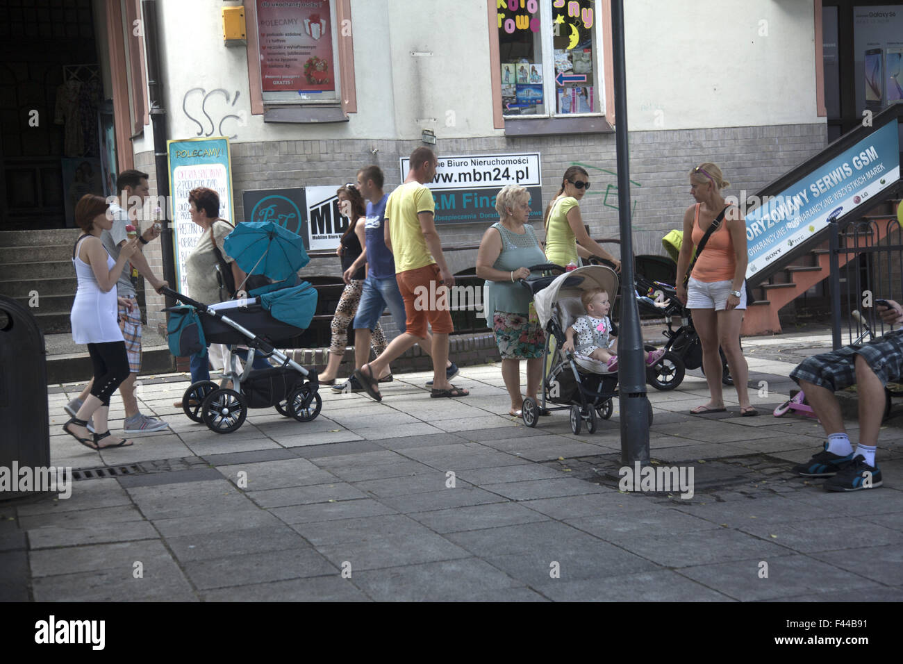 People stroll leisurely pushing baby strollers and eating ice cream in ...
