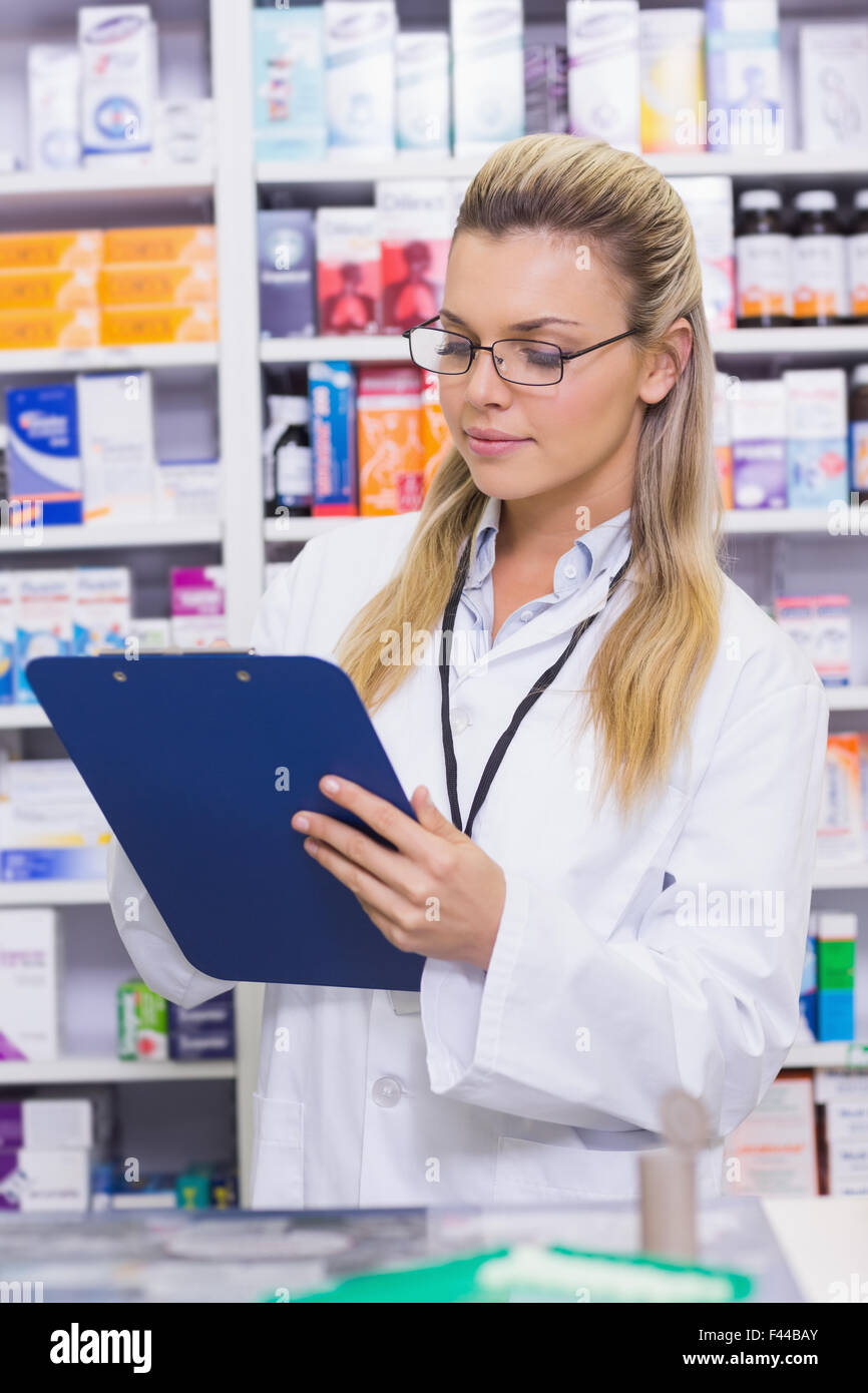 Pharmacist writing on clipboard Stock Photo - Alamy