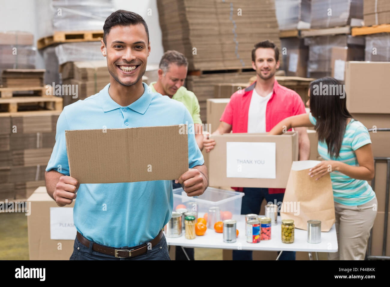 Smiling volunteer showing a poster Stock Photo - Alamy