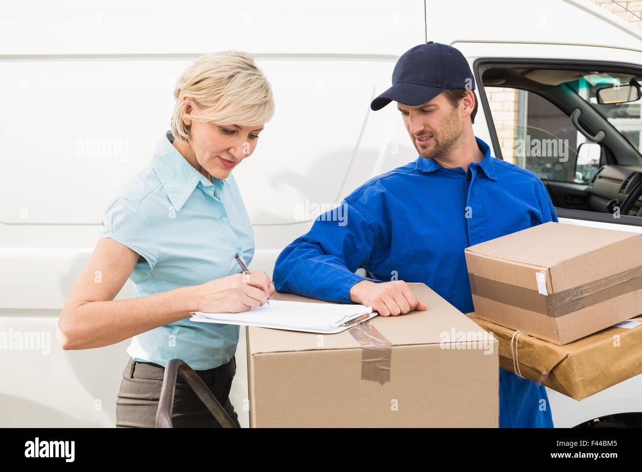 Happy delivery man with customer Stock Photo - Alamy