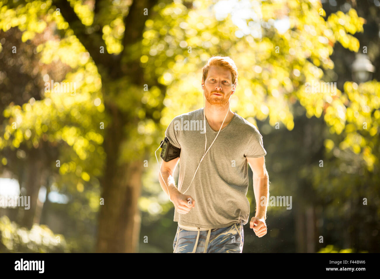 Young man running in the autumn park Stock Photo - Alamy