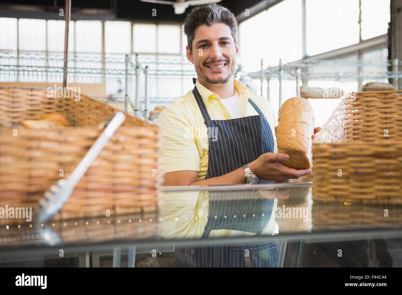 Smiling worker showing a loaf Stock Photo - Alamy