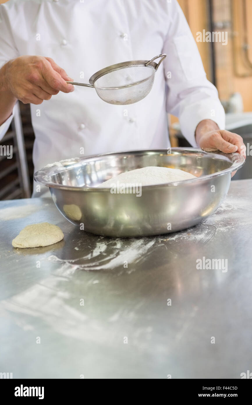 Baker working with sieve and bowl Stock Photo - Alamy