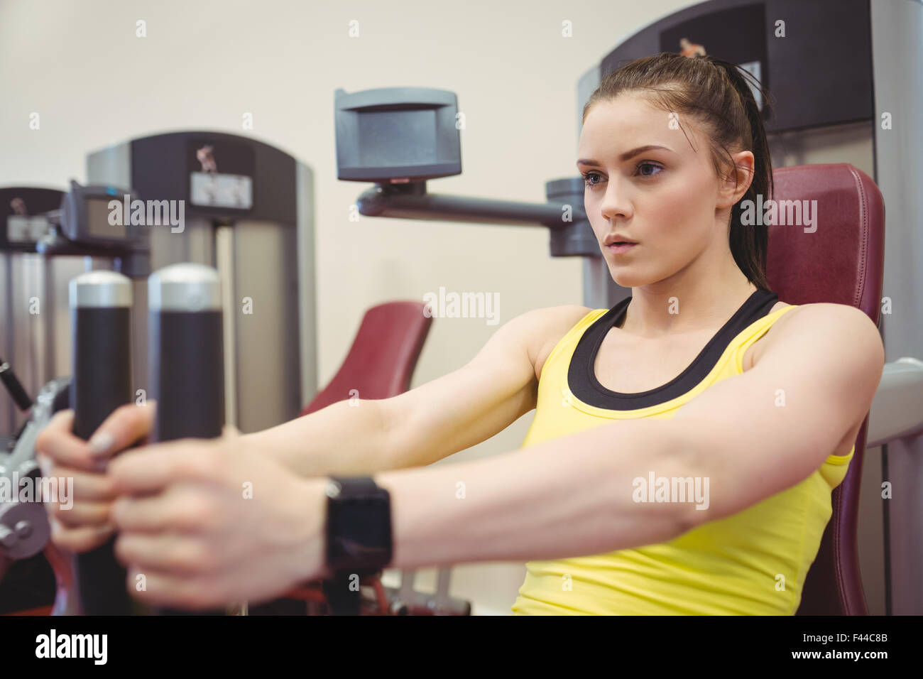 Fit woman using weights machine Stock Photo - Alamy