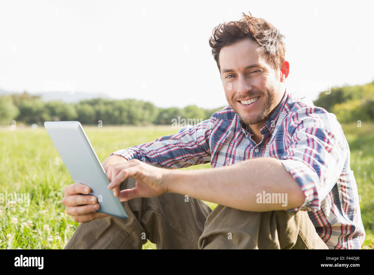 Young man using tablet in the countryside Stock Photo - Alamy