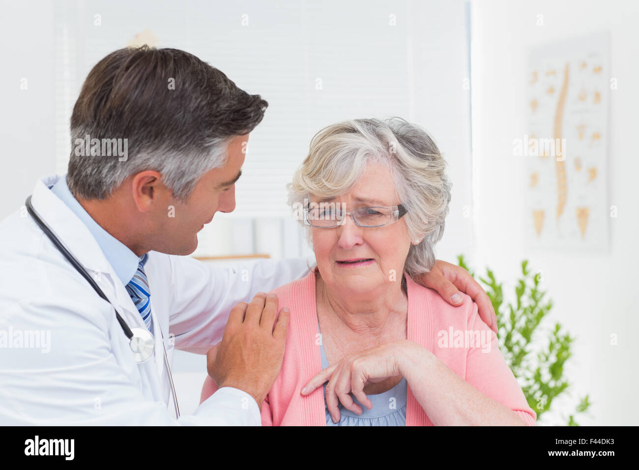 Doctor consoling senior patient in clinic Stock Photo - Alamy
