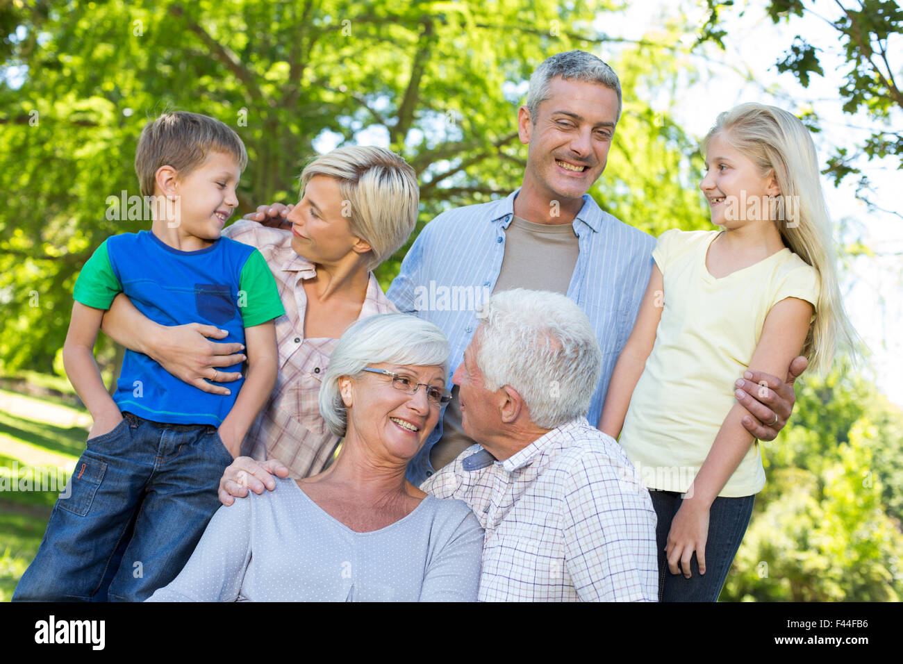 Happy family talking in the park Stock Photo - Alamy