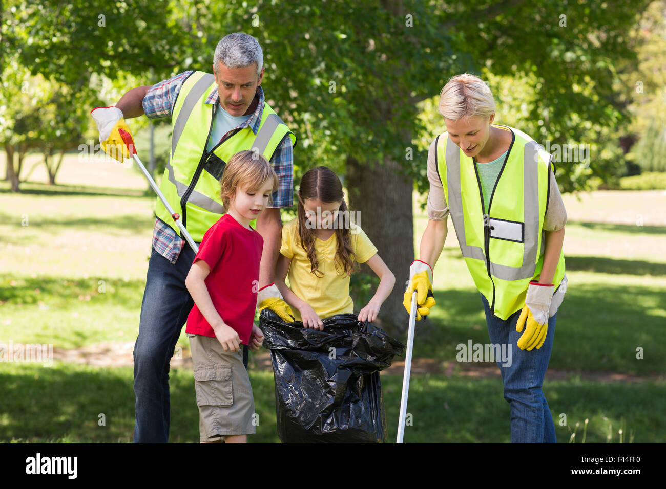 Happy family collecting rubbish Stock Photo - Alamy