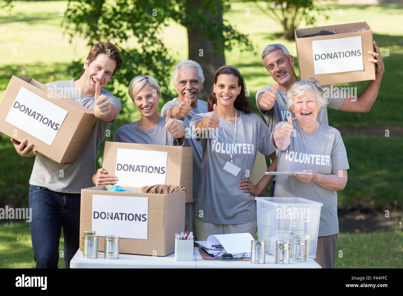 Happy volunteer family with thumbs up Stock Photo - Alamy