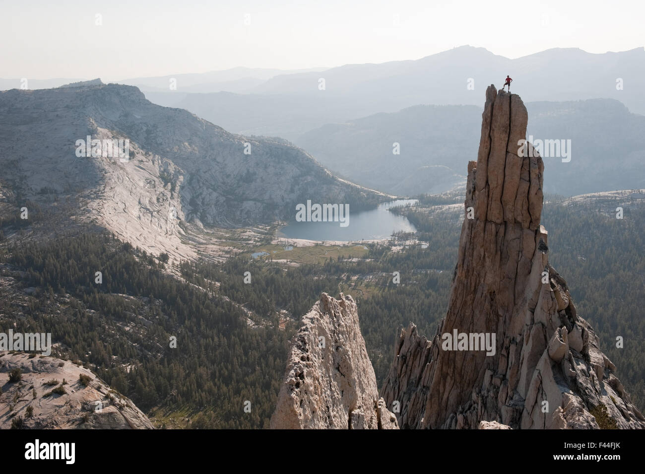 Climber standing on top of Eichorn Pinnacle on Cathedral Peak in ...