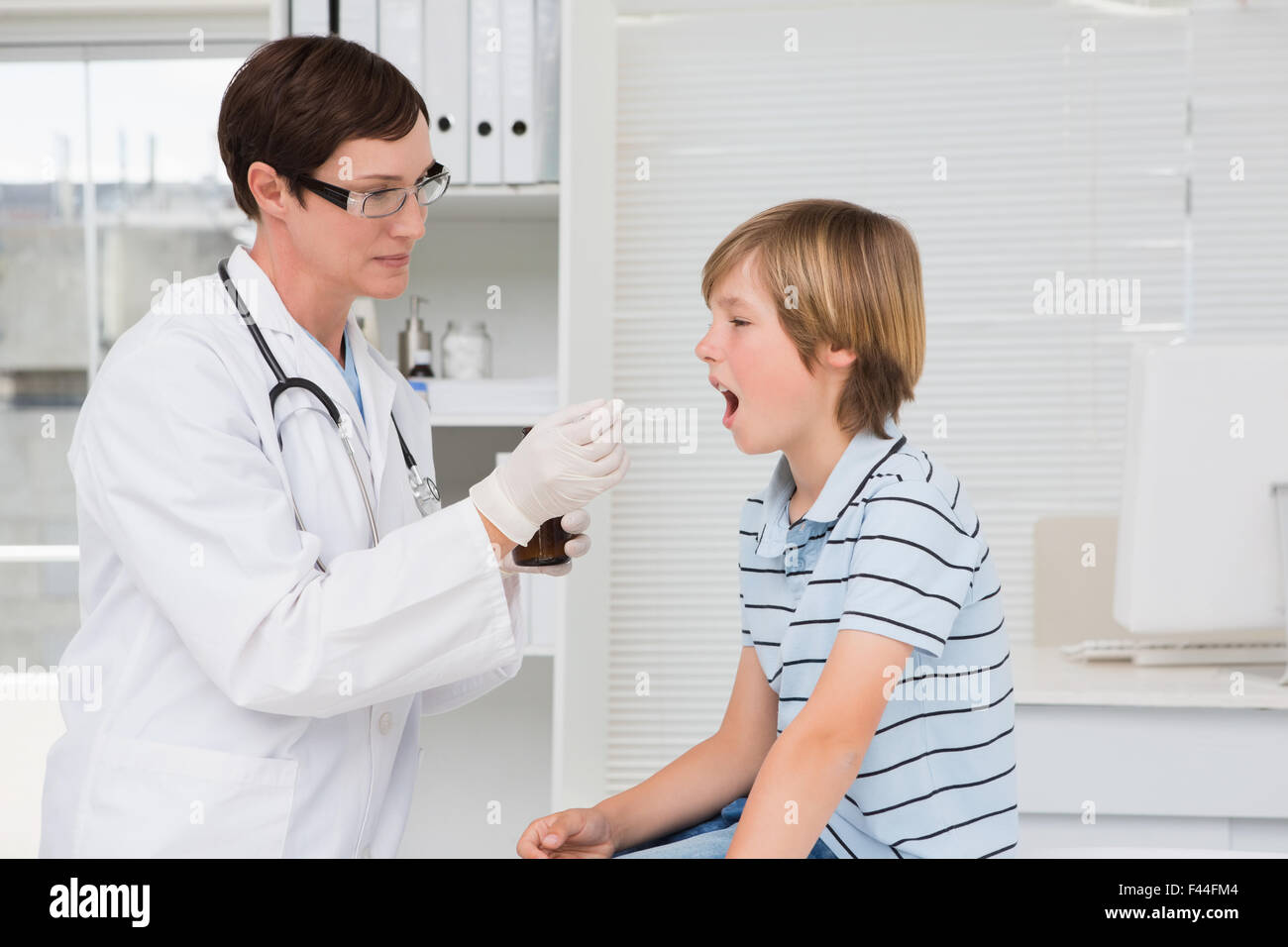 Doctor giving syrup to little boy Stock Photo - Alamy