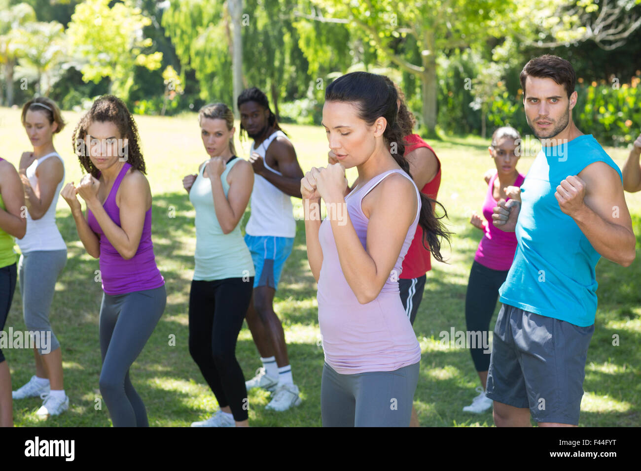 Fitness group working out in park Stock Photo - Alamy