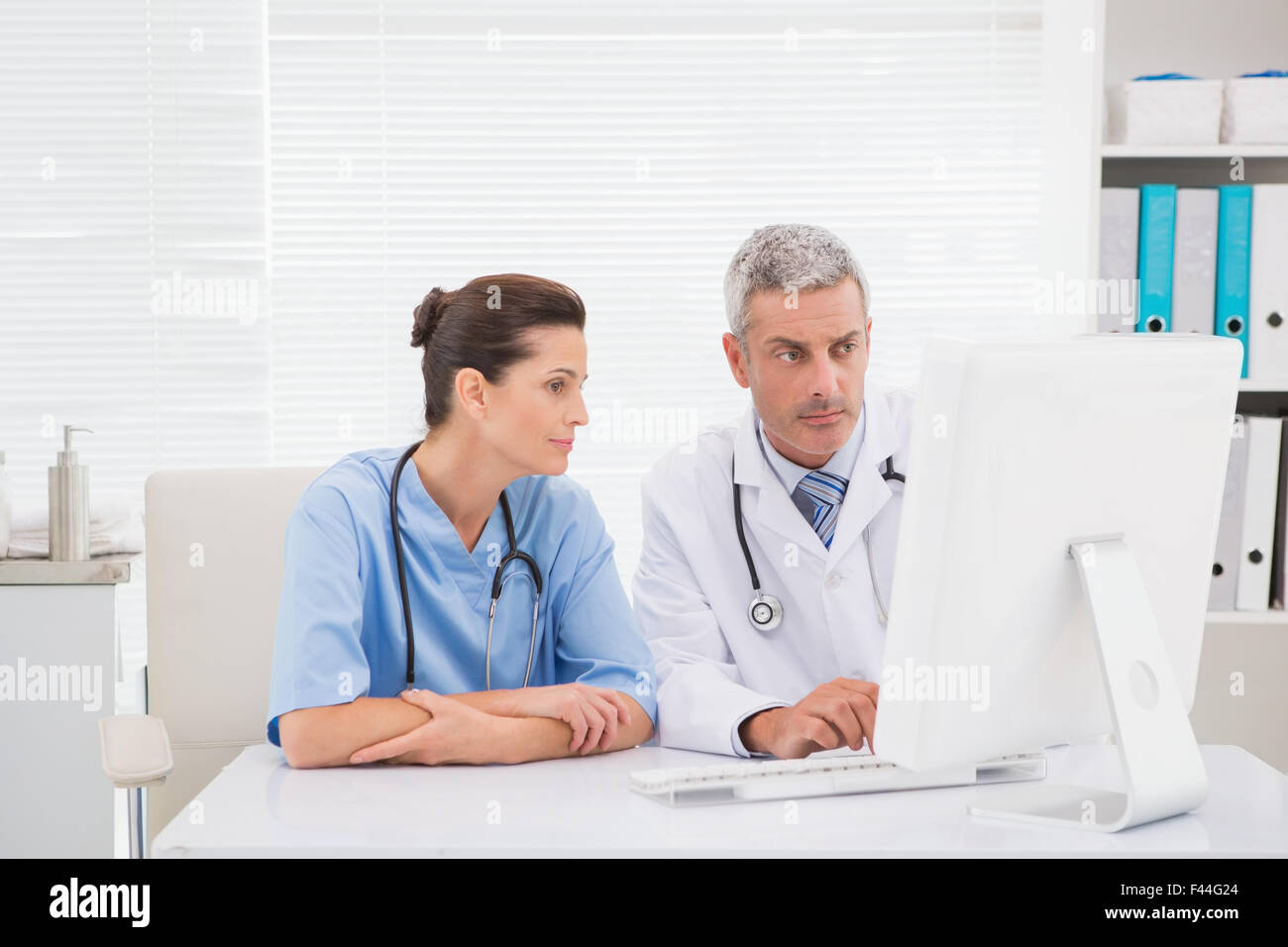 Doctors looking at computer Stock Photo - Alamy