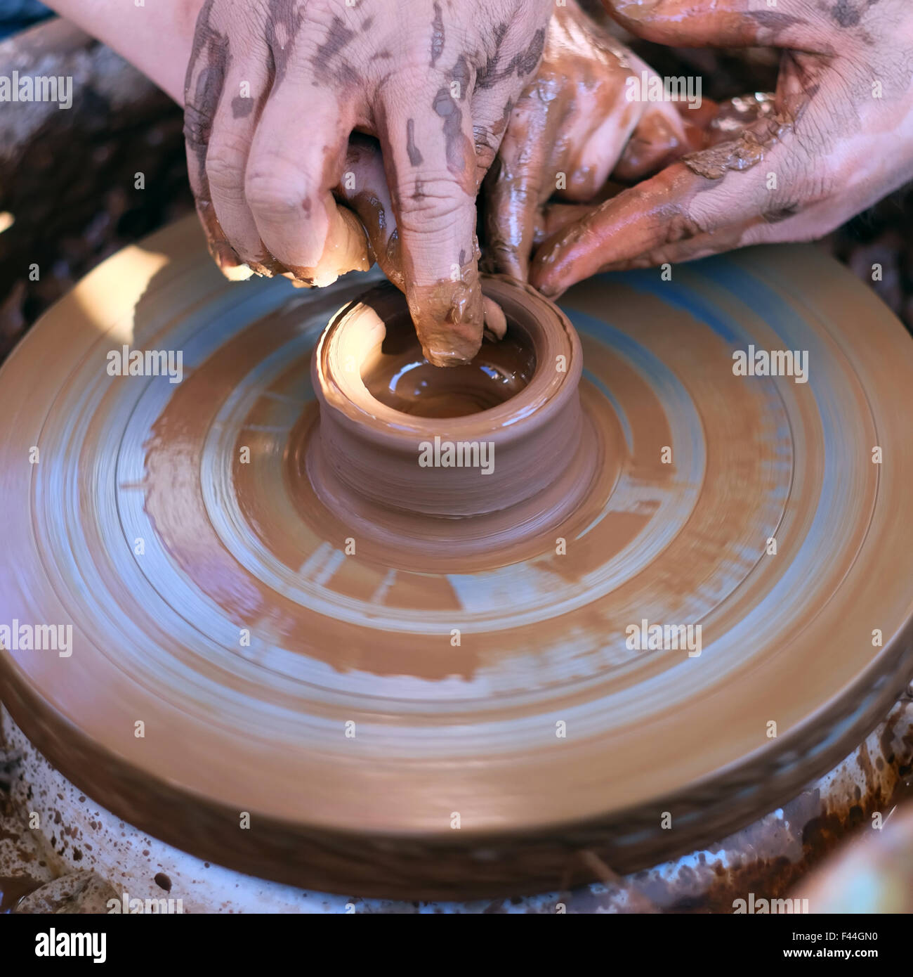 Hands working on pottery wheel Stock Photo - Alamy