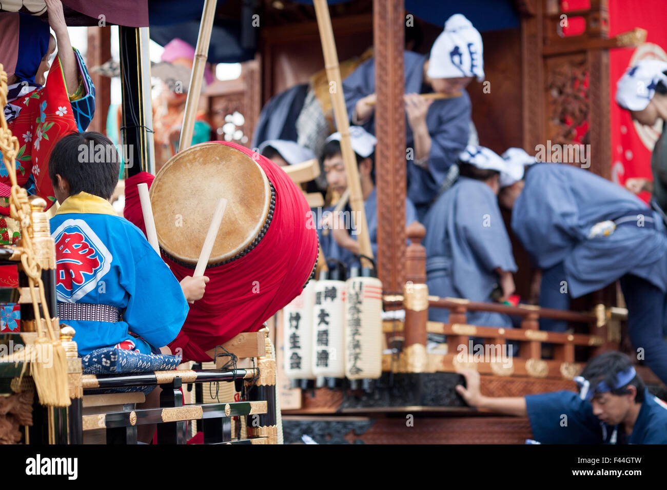 Boy playing taiko drums flute players on traditional Japanese floats ...