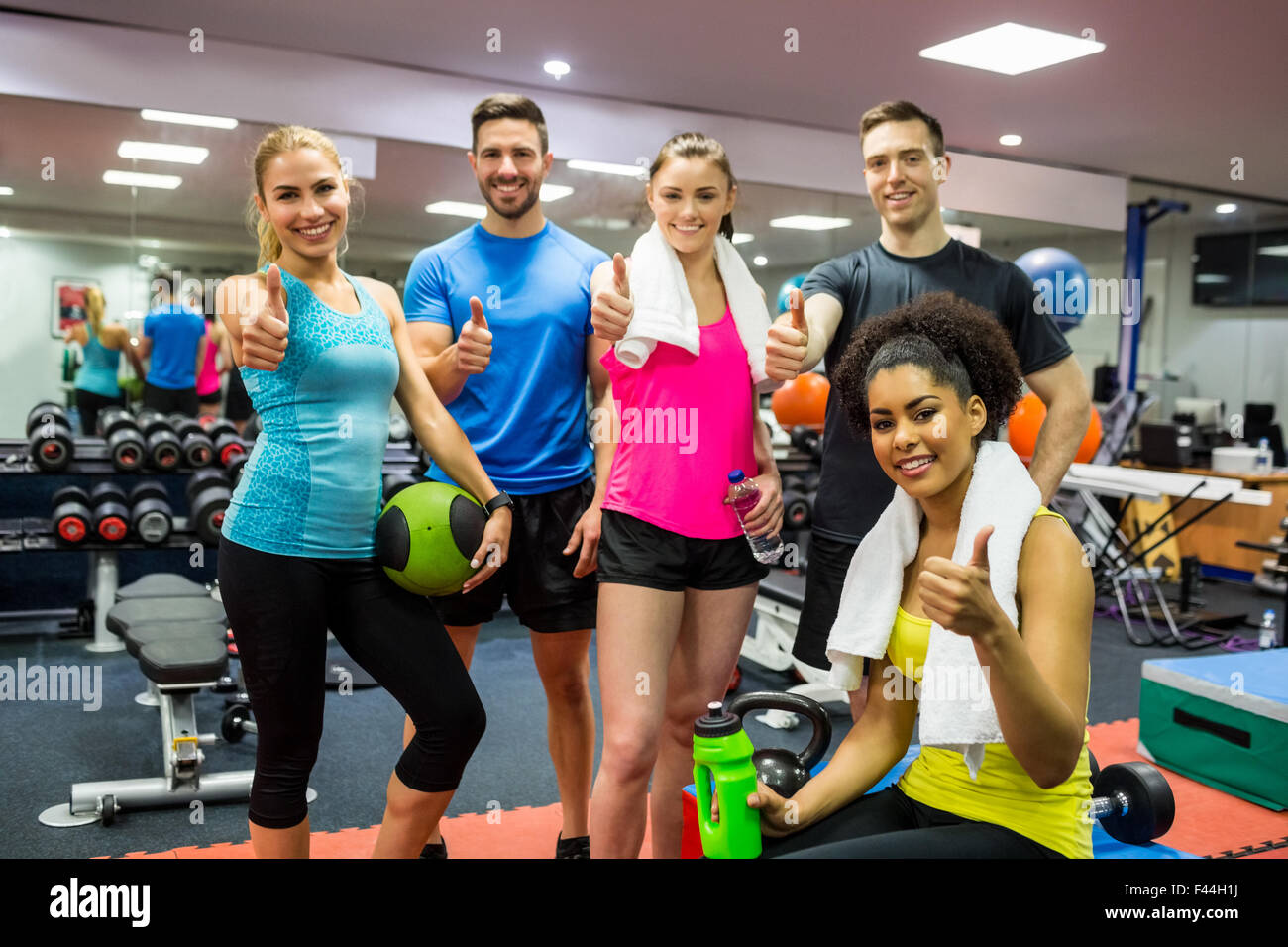 Fit people smiling at camera in weights room Stock Photo - Alamy