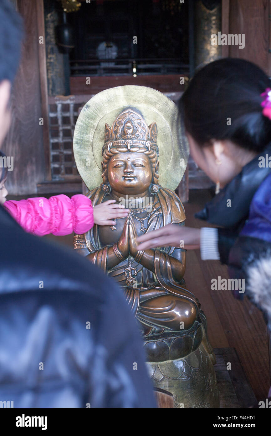 Buddha bronze statue in prayer people touching it Stock Photo - Alamy