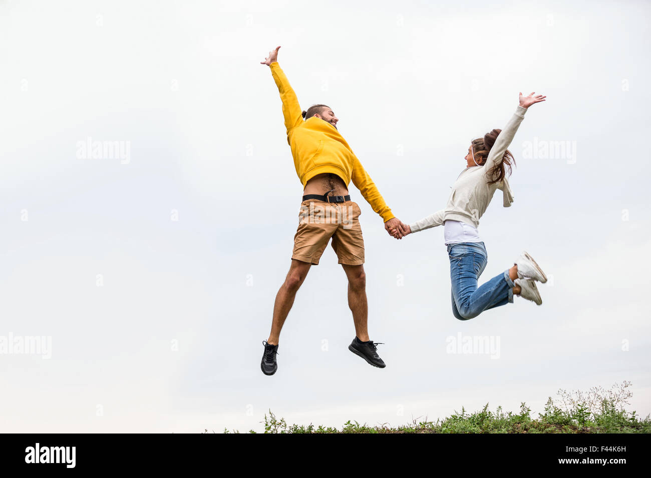 Couple jumping on a hike Stock Photo - Alamy