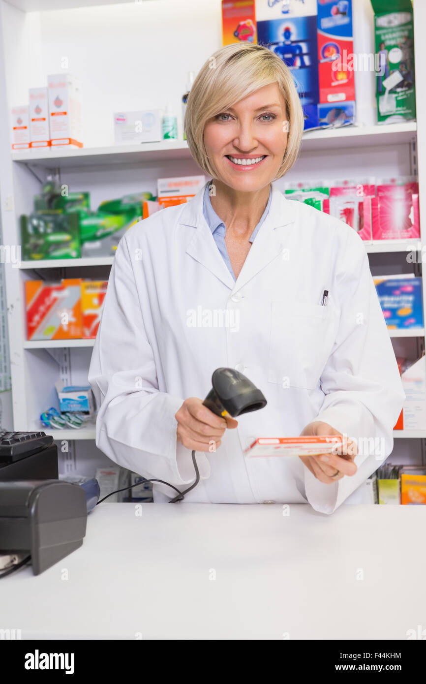 Smiling pharmacist scanning box of medicine Stock Photo - Alamy