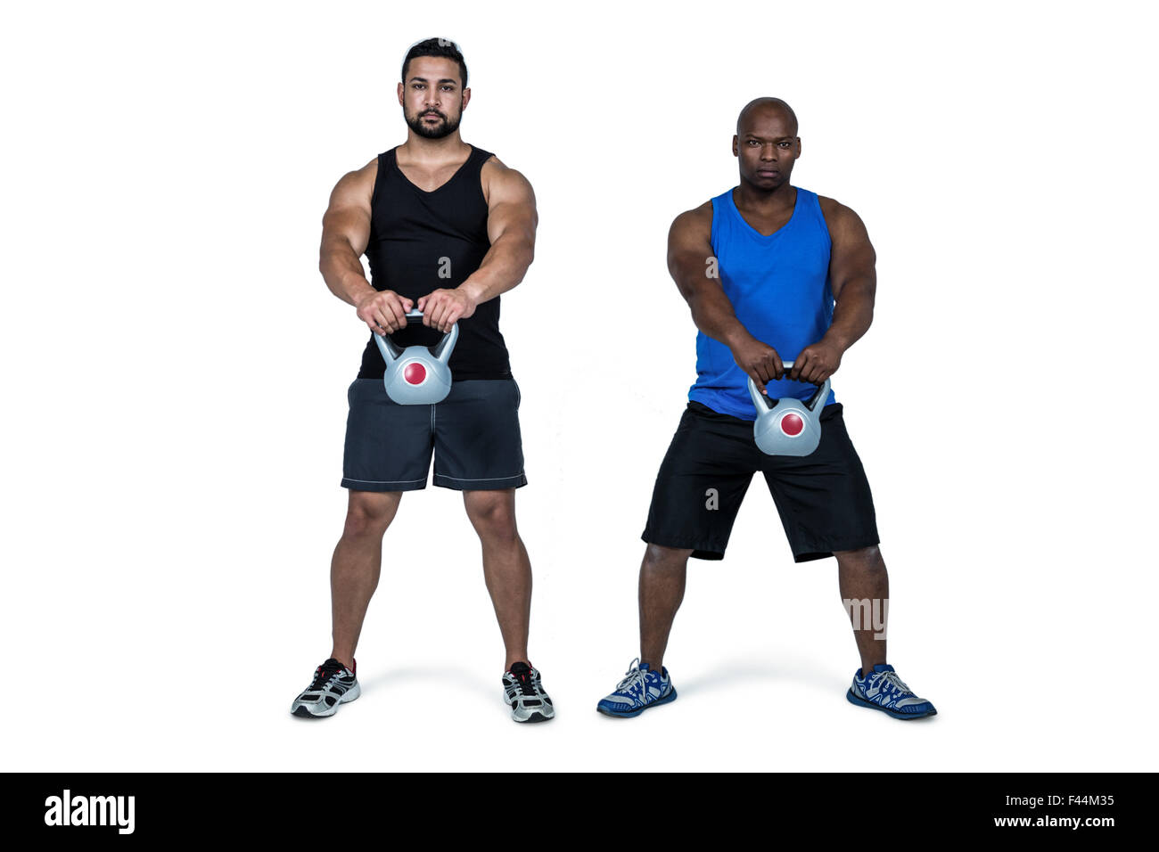Strong friends lifting kettlebells together Stock Photo - Alamy