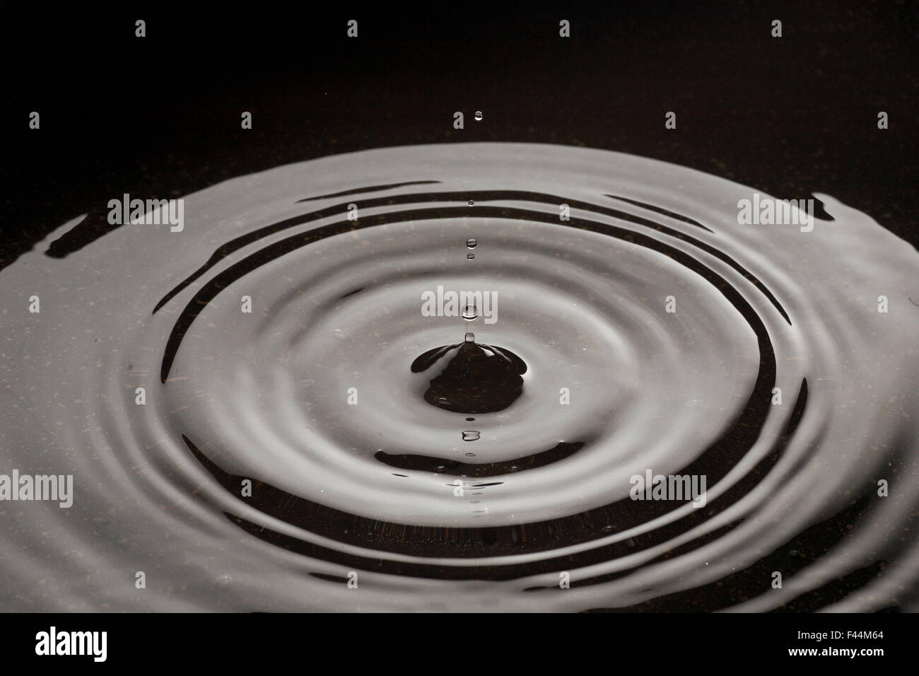 Water droplets making ripples in water Stock Photo - Alamy