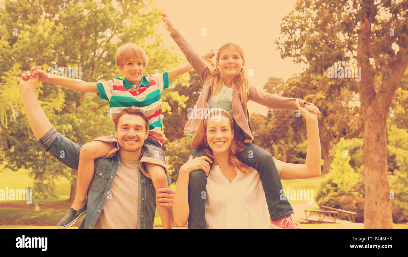 Parents carrying kids on shoulders at park Stock Photo - Alamy