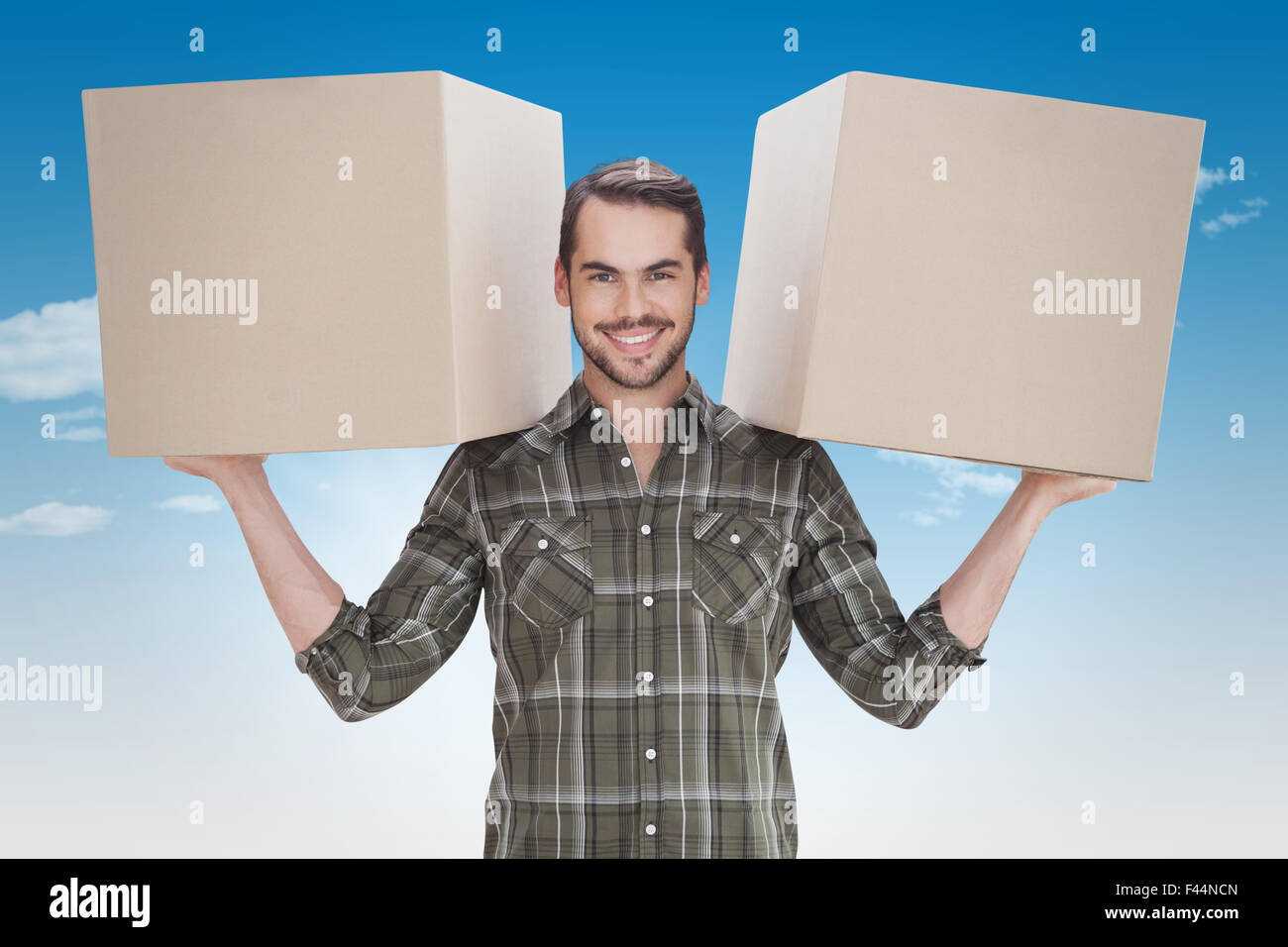 Composite image of happy man holding boxes Stock Photo - Alamy