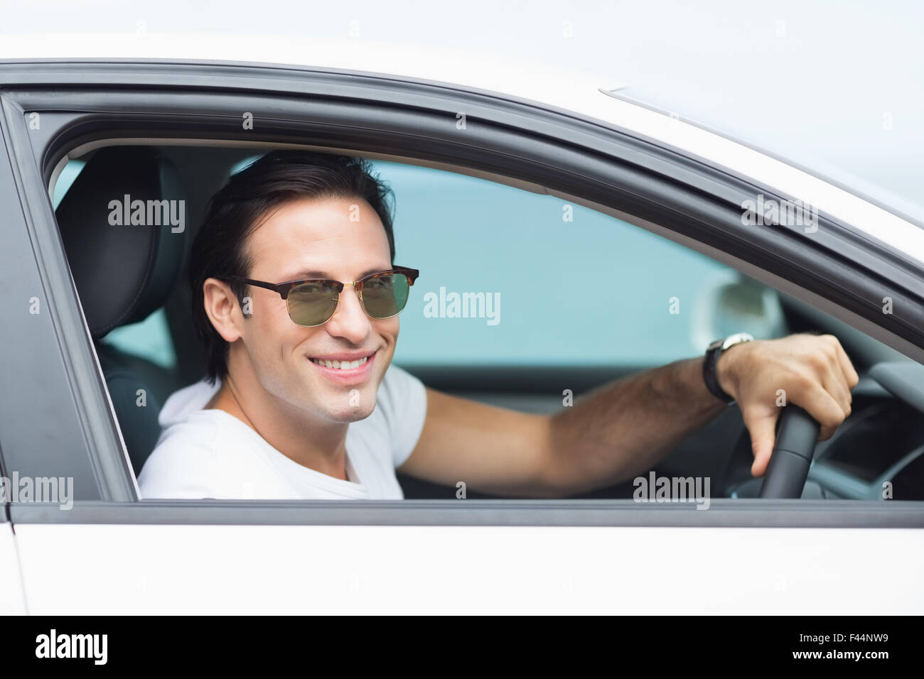 Man driving and smiling at camera Stock Photo - Alamy